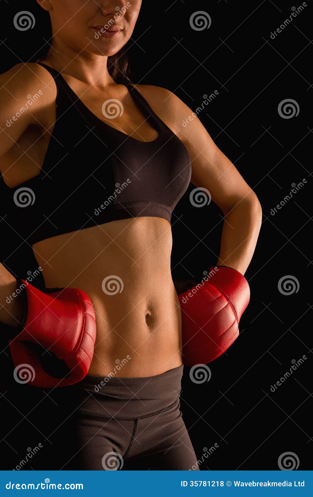 Mid Section Of Young Sporty Woman Posing And Wearing Boxing Gloves