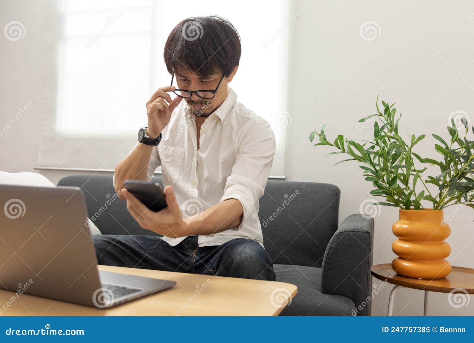 Middle Age Asian Man Squint Eye To Look at the Phone Due To Long Eye ...