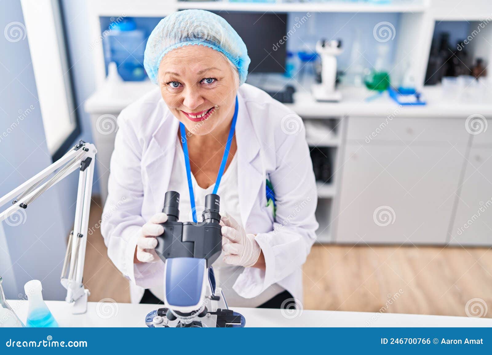 Middle Age Blonde Woman Wearing Scientist Uniform Using Microscope at ...