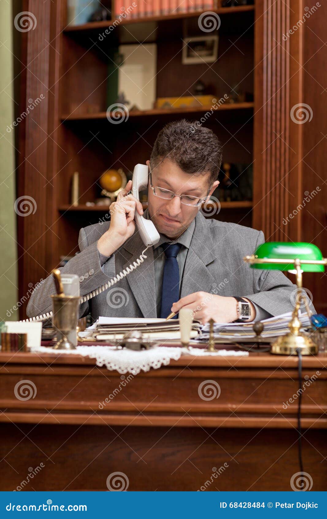 Middle Age Businessman Sitting at a Table in the Office and Using Phone ...