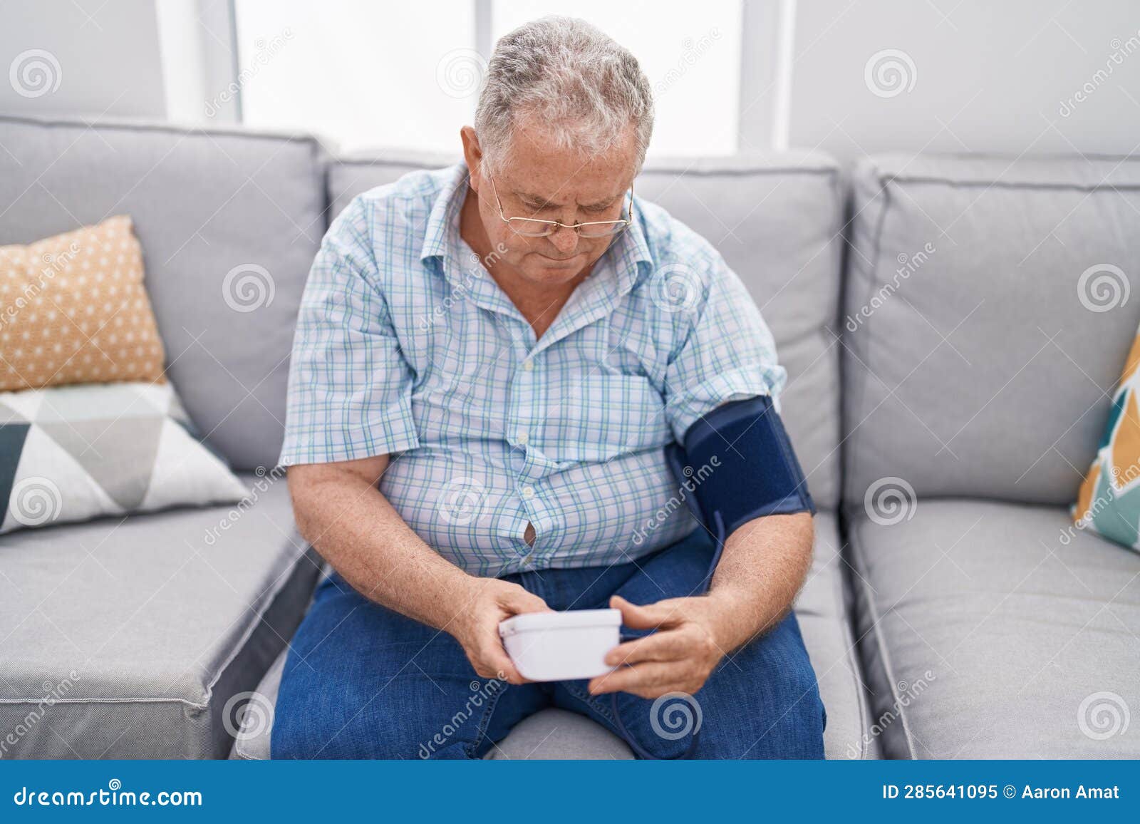 Middle Age Grey-haired Man Measuring Pulse Using Tensiometer at Home ...