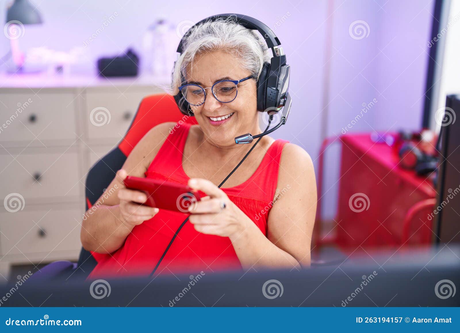 Middle Age Grey-haired Woman Streamer Using Computer and Smartphone at ...