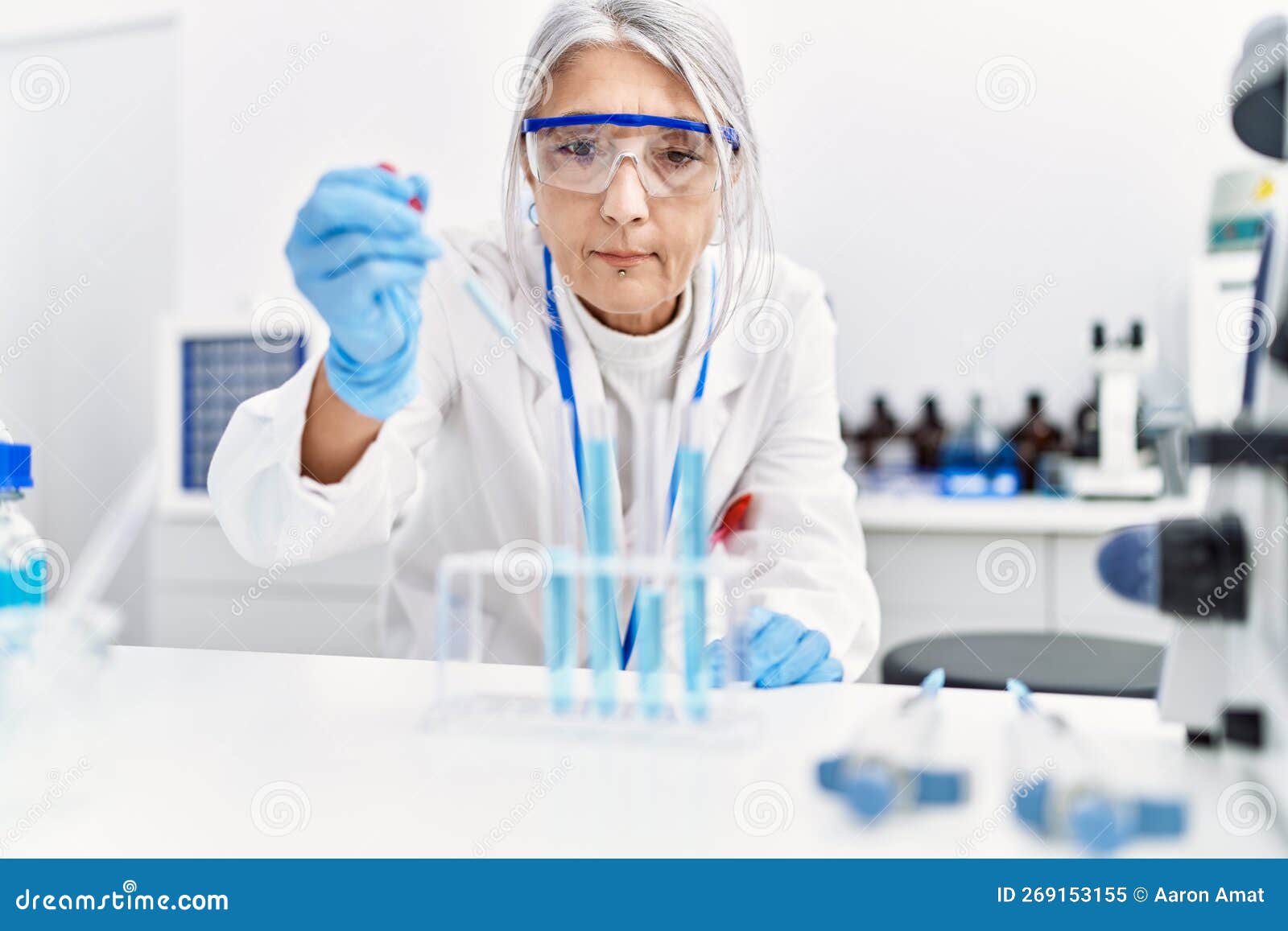 Middle Age Grey-haired Woman Wearing Scientist Uniform Using Pipette at ...