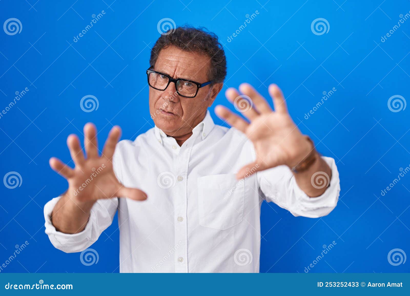 Middle Age Hispanic Man Standing Over Blue Background Afraid and ...