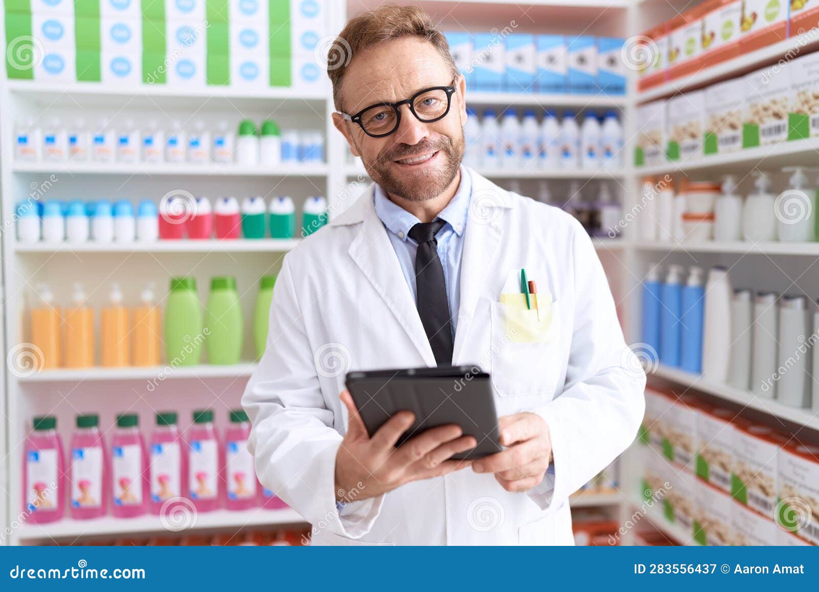 Middle Age Man Pharmacist Using Touchpad Working at Pharmacy Stock ...
