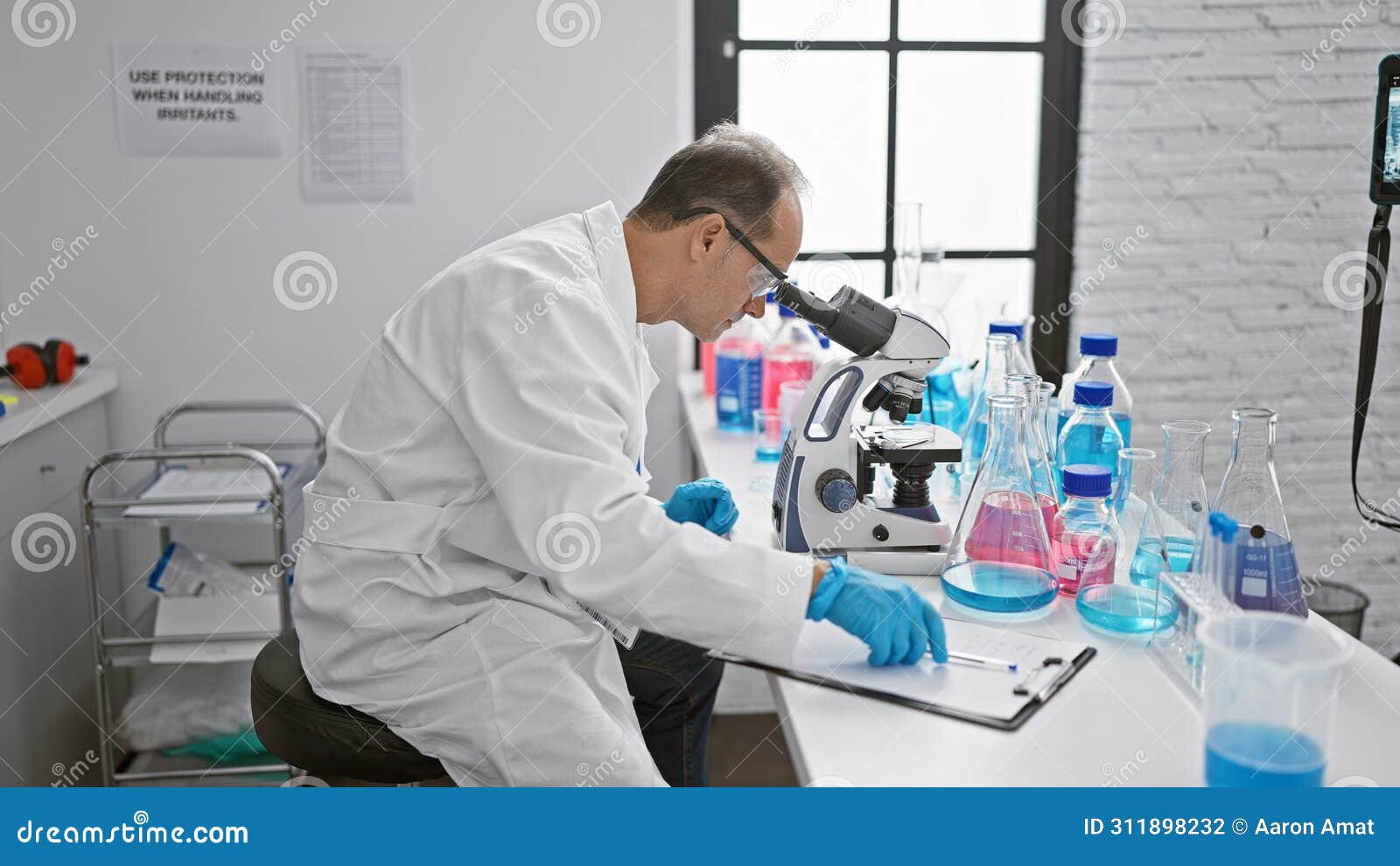 Middle Age Man Scientist Using Microscope at Laboratory Stock Photo ...