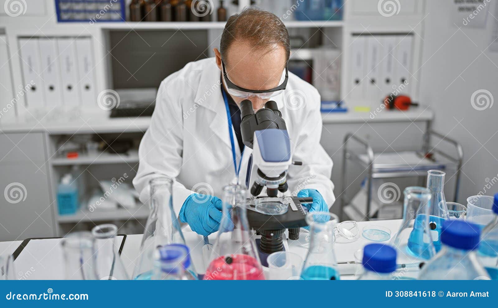 Middle Age Man Scientist Using Microscope at Laboratory Stock Photo ...