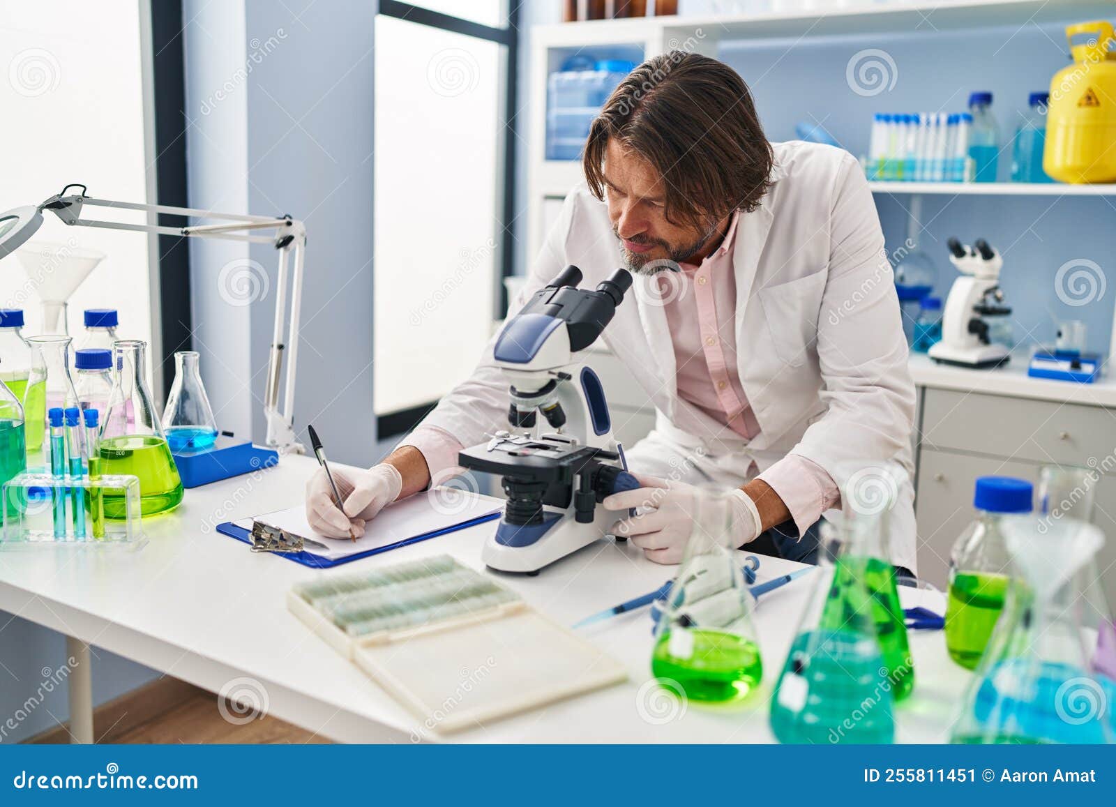 Middle Age Man Scientist Using Microscope Writing on Document at ...