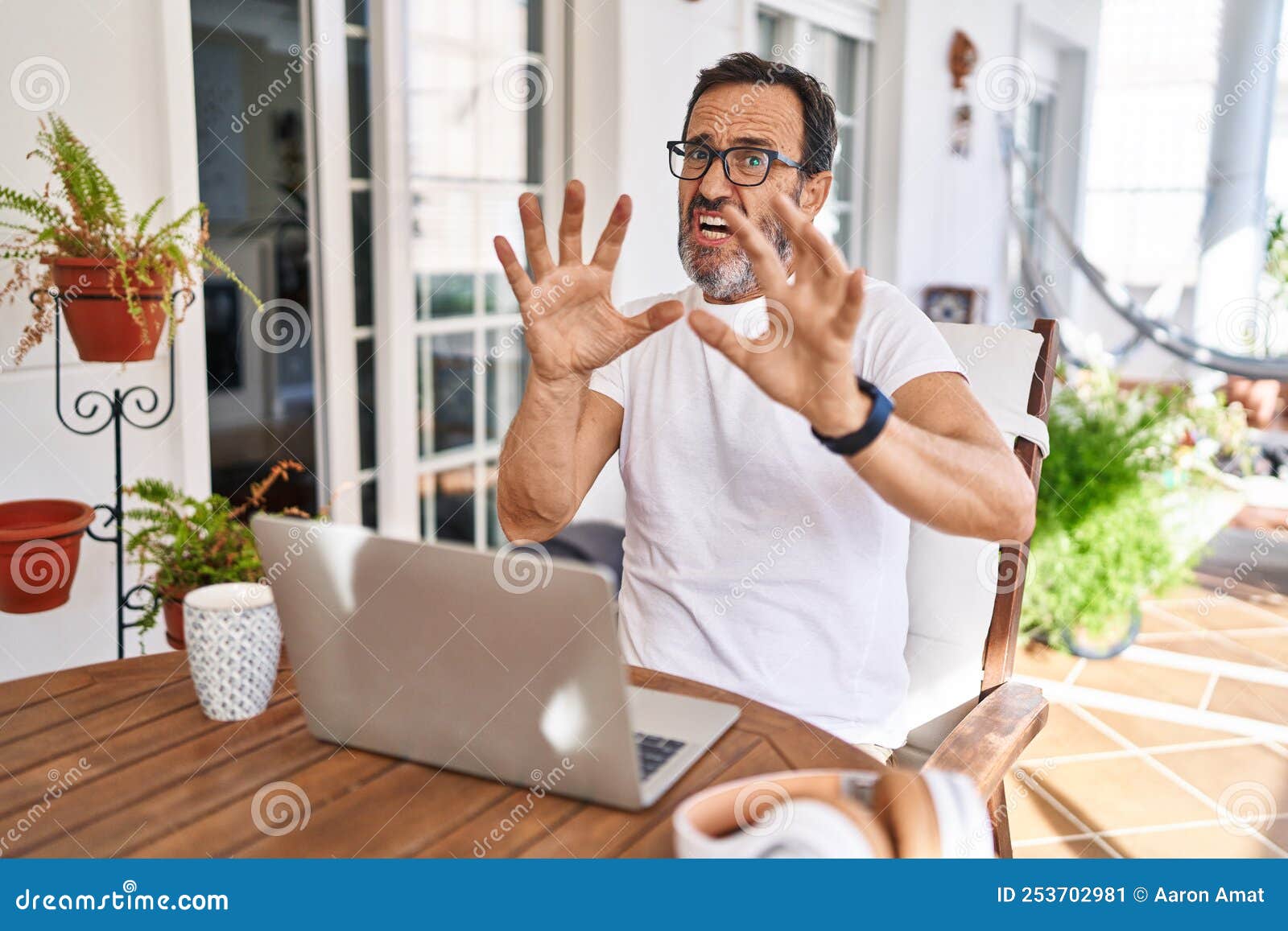 Middle Age Man Using Computer Laptop at Home Afraid and Terrified with ...