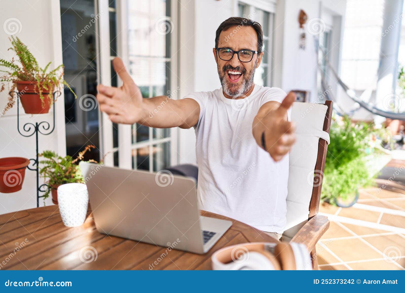 Middle Age Man Using Computer Laptop at Home Looking at the Camera ...