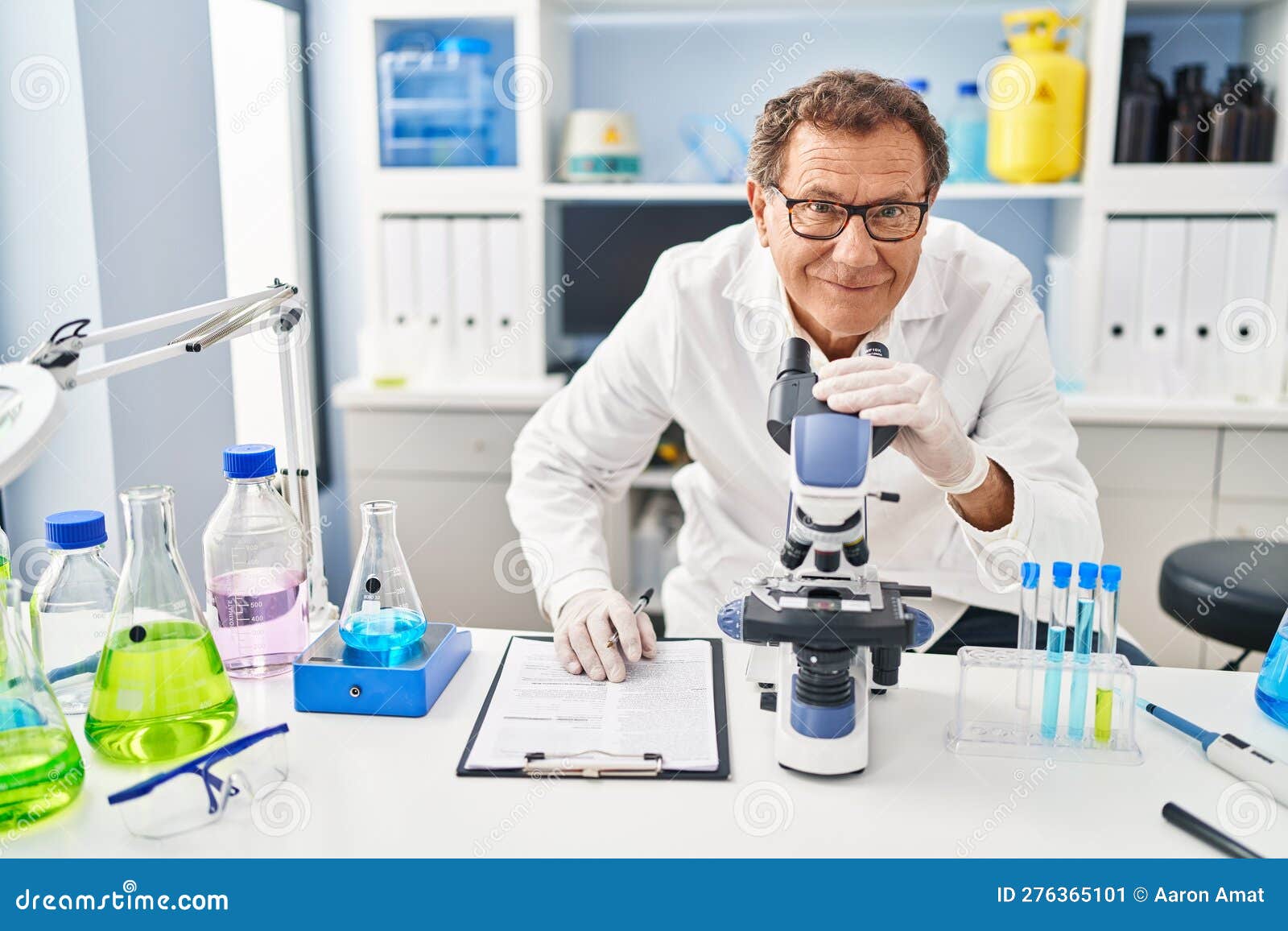 Middle Age Man Wearing Scientist Uniform Using Microscope at Laboratory ...