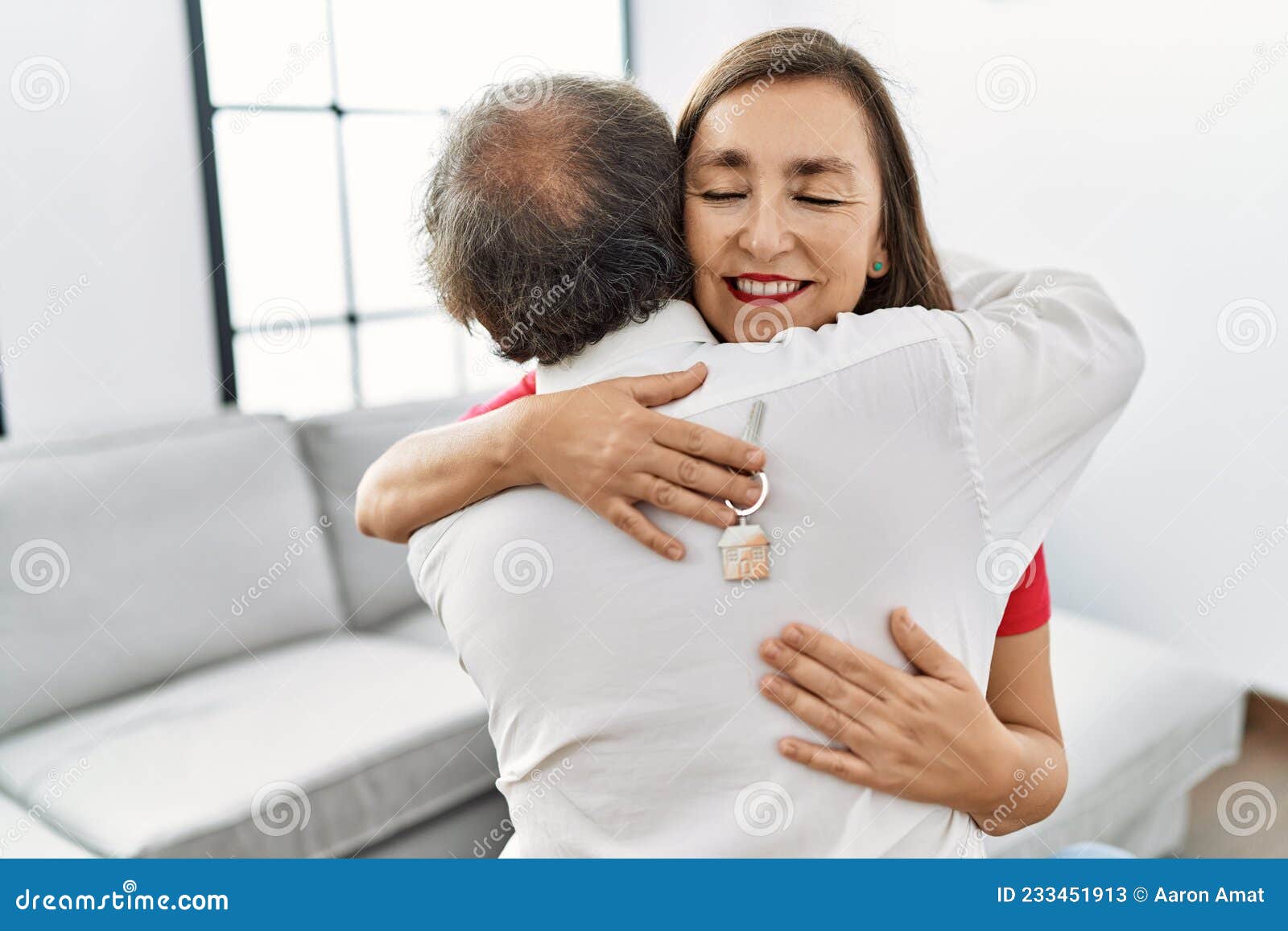 Middle Age Man And Woman Couple Hugging Each Other Holding Key Of New