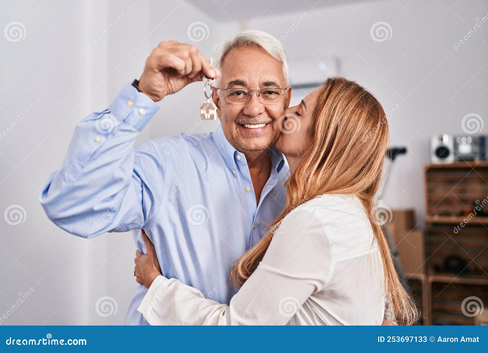 Middle Age Man And Woman Couple Hugging Each Other Holding Key Of New