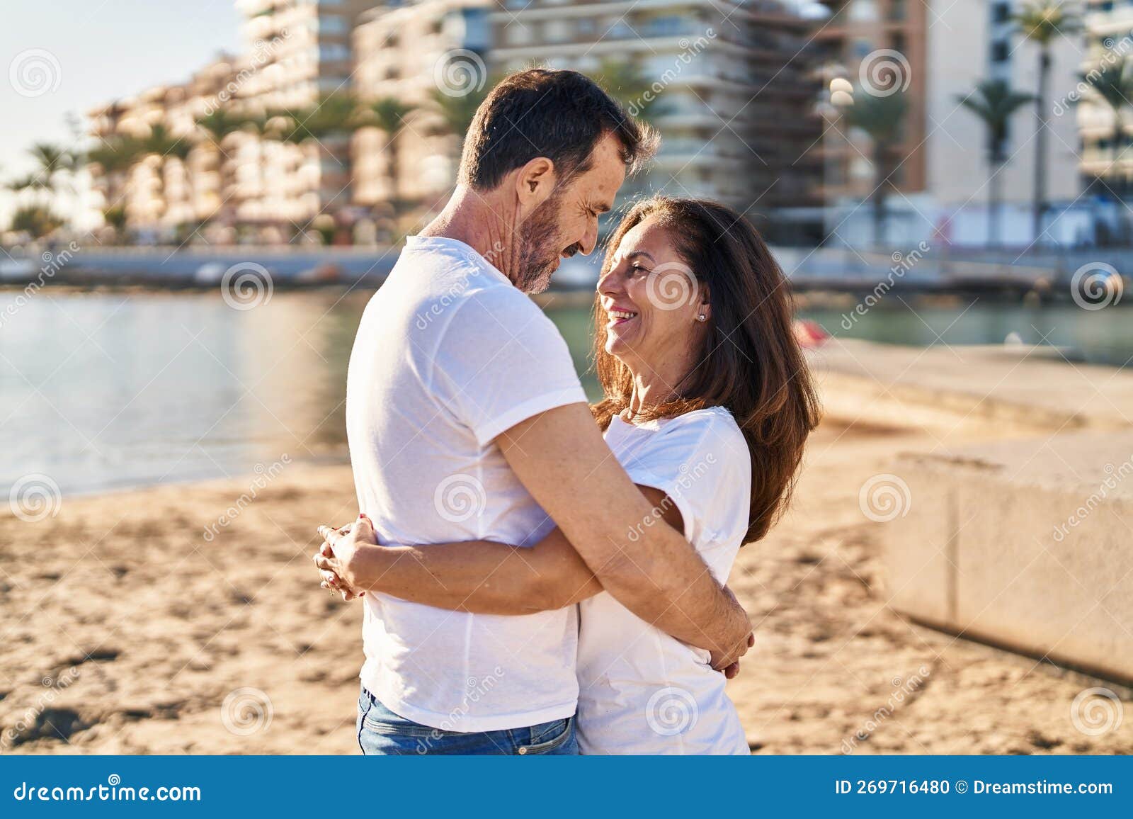 Middle Age Man And Woman Couple Hugging Each Other Standing At Seaside