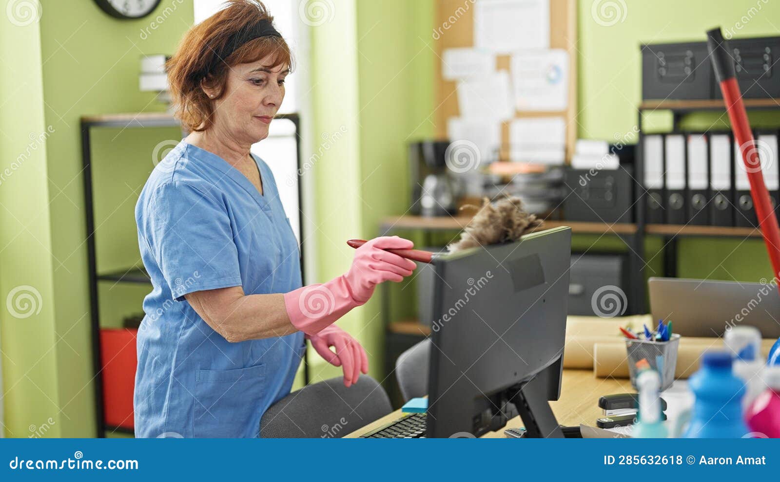 Middle Age Woman Professional Cleaner Cleaning Computer Using Duster at ...