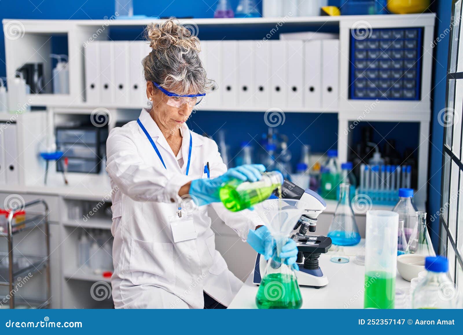 Middle Age Woman Scientist Measuring Liquid at Laboratory Stock Image ...