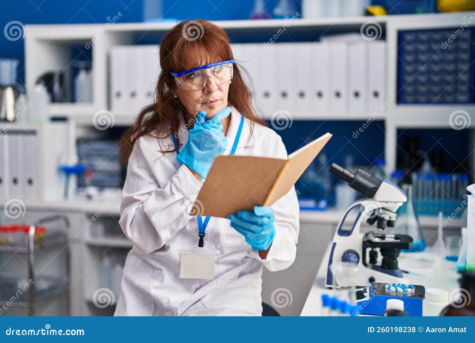 Middle Age Woman Scientist Reading Book at Laboratory Stock Photo ...