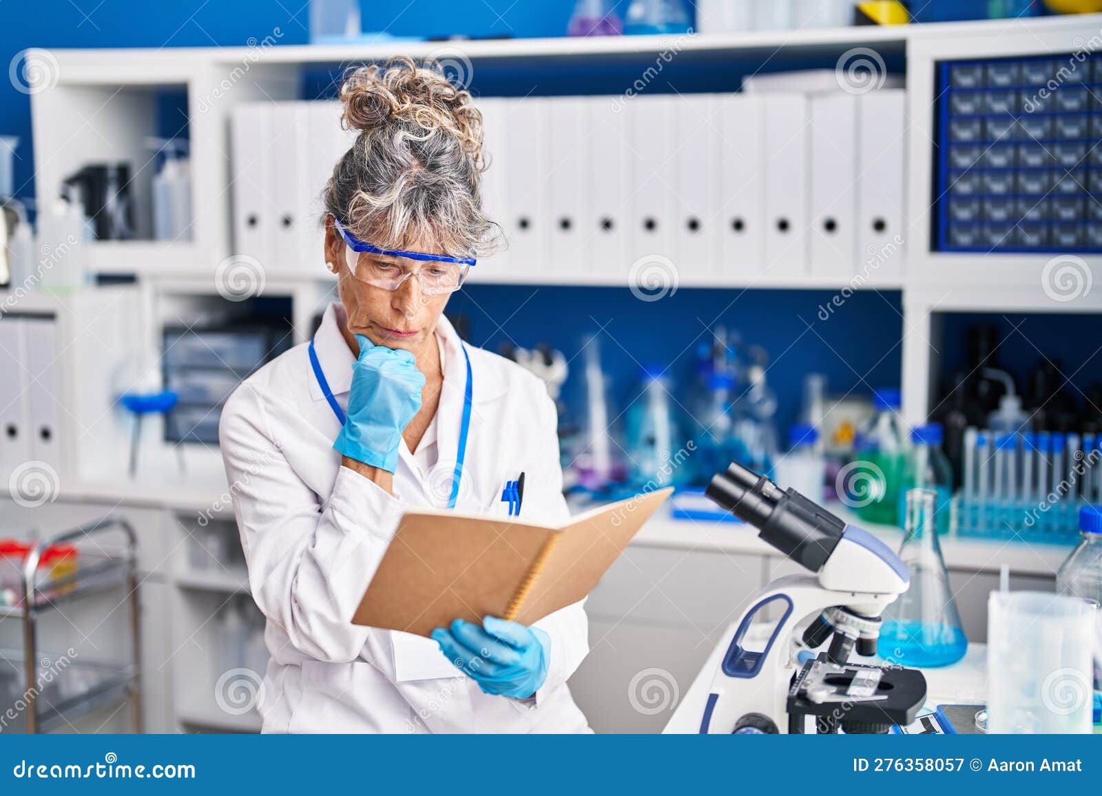 Middle Age Woman Scientist Reading Book at Laboratory Stock Image ...