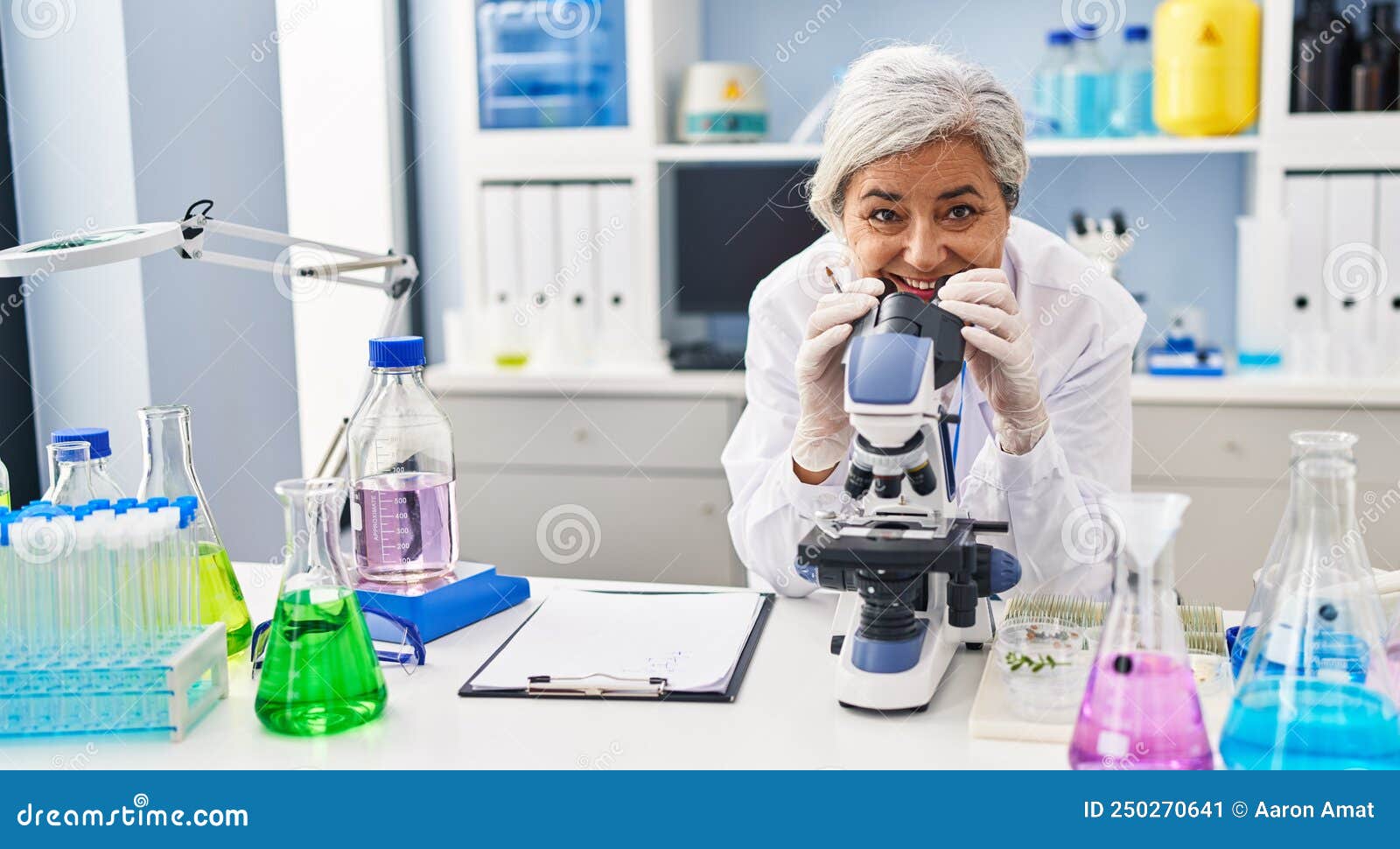 Middle Age Woman Wearing Scientist Uniform Using Microscope at ...