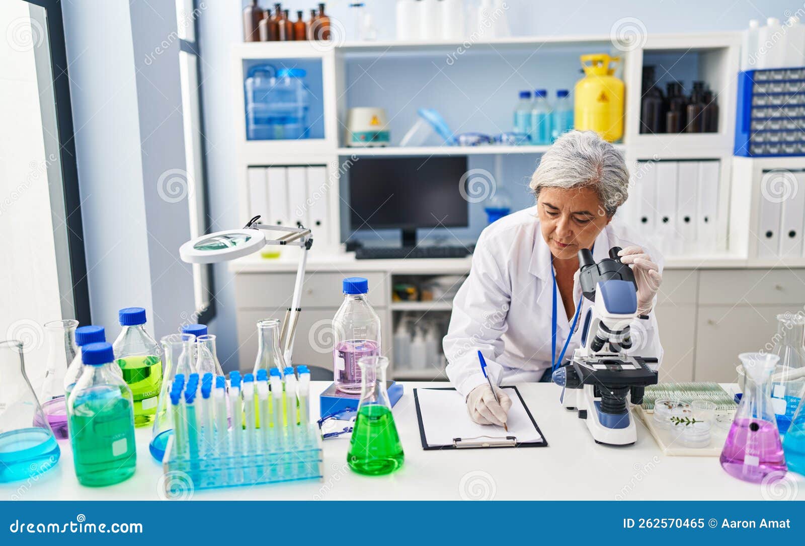 Middle Age Woman Wearing Scientist Uniform Write on Document at ...