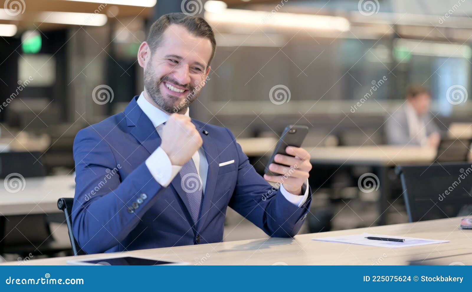 Middle Aged Businessman Celebrating Success on Smartphone at Work Stock ...