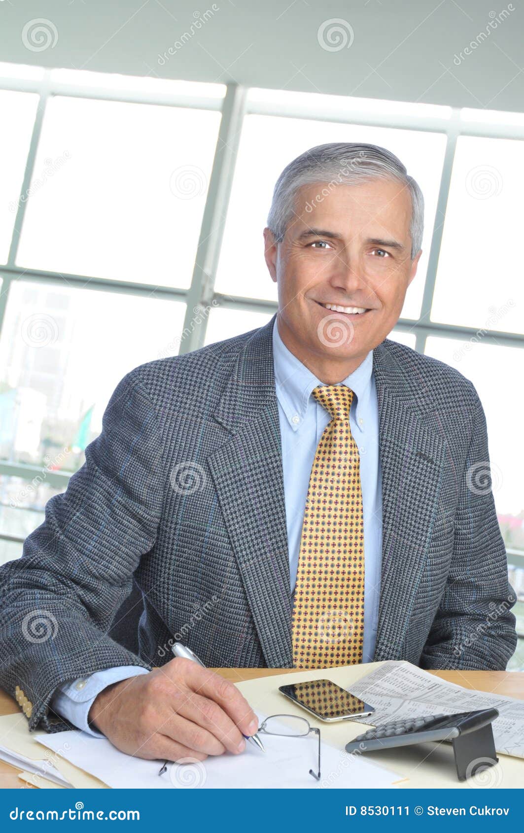 Middle Aged Businessman Sitting at Desk in Office Stock Image - Image ...