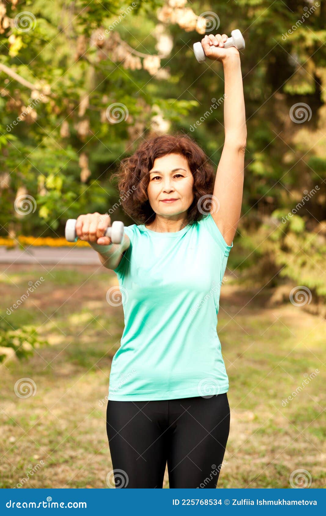 Middle Aged Elderly Active Woman Doing Exercise with Dumbbells in a ...