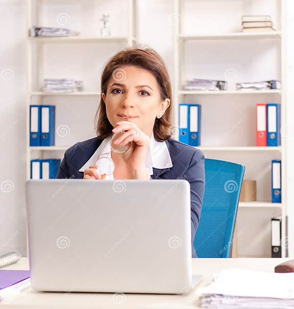 Middle-aged Female Employee Sitting at the Office Stock Photo - Image ... Middle-aged Female Employee Sitting at the Office Stock Photo - Image ...