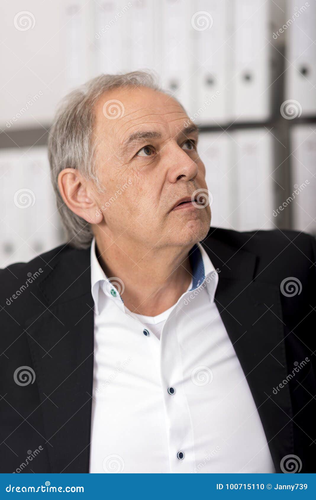 Middle-aged Man is Standing in Front of a Shelf Wall with Documents ...