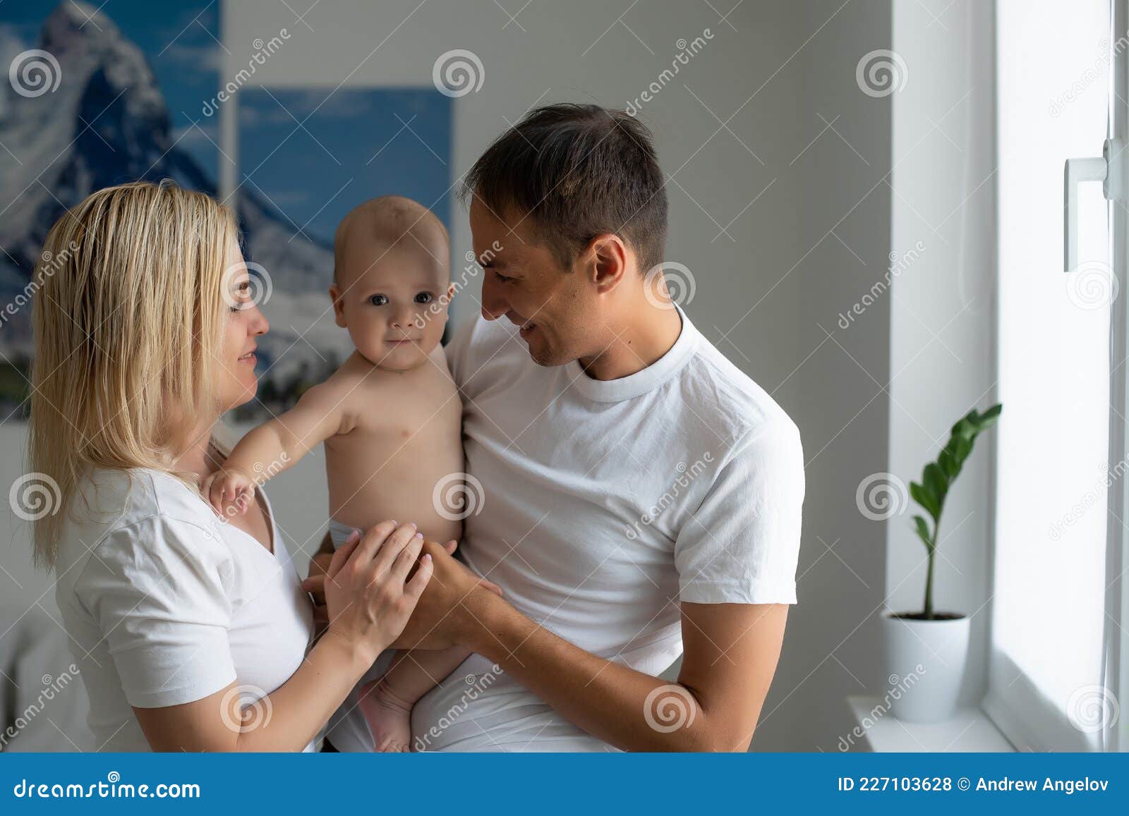 Middle-aged Parents with Baby in White Bedroom Stock Photo - Image of ...