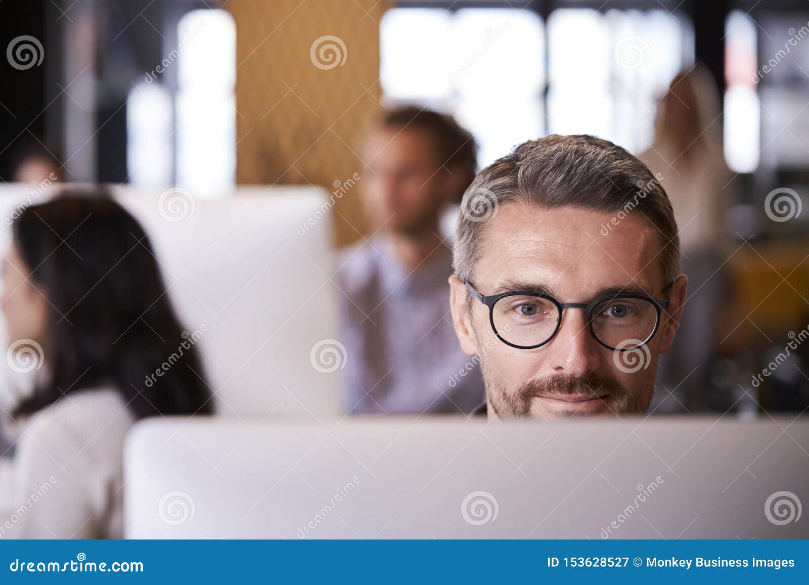 Middle Aged White Male Creative Using a Computer in a Busy Office ...