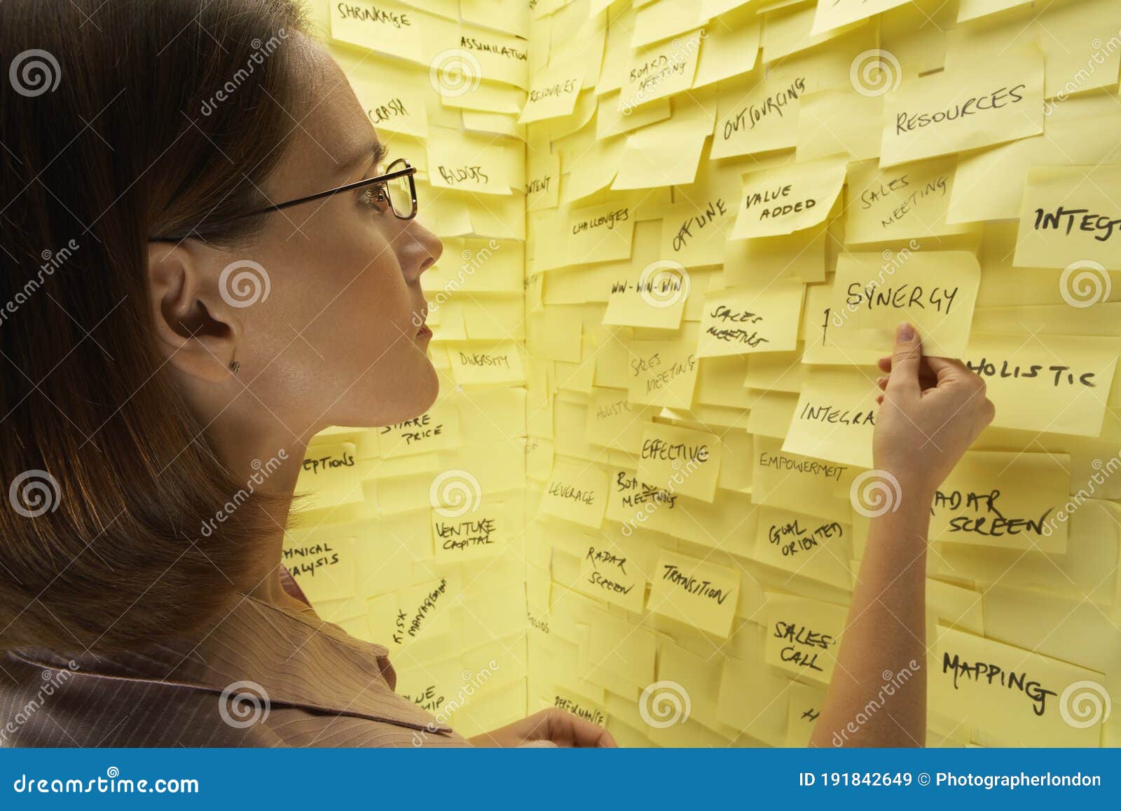 Middle Aged Woman Standing In Front Of Wall Covered In Sticky Notes