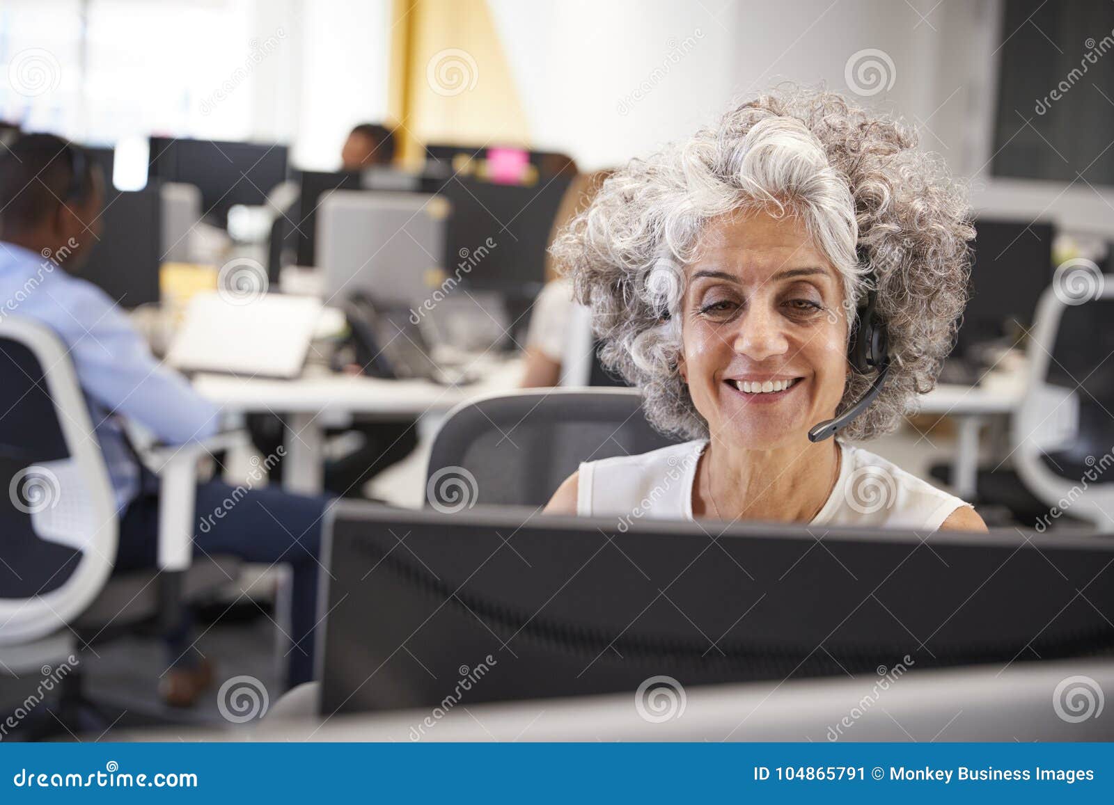 Middle Aged Woman Working at Computer with Headset in Office Stock ...