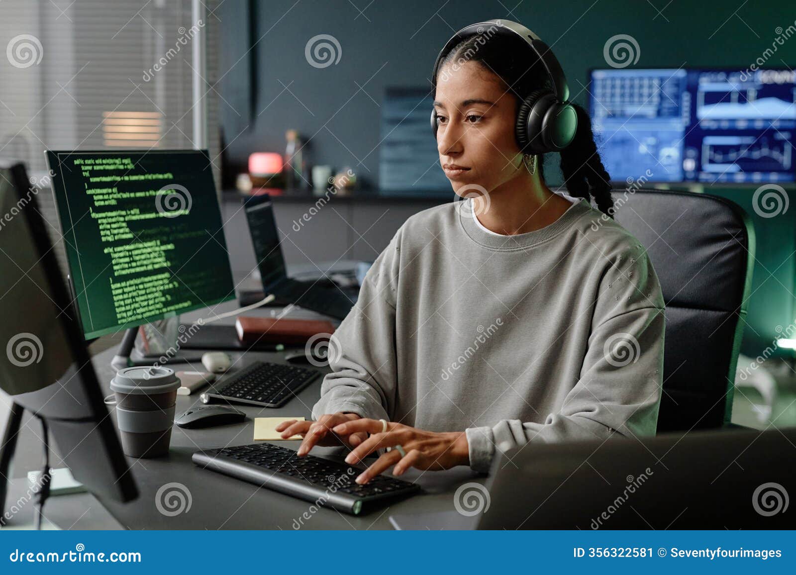 Middle Eastern Female Programmer in Headphones Focused on Coding on Computer in Office Stock ...