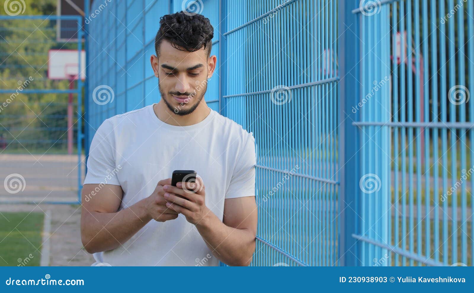 Middle Eastern Indian Man Holding Phone in Hands Texting Message or ...