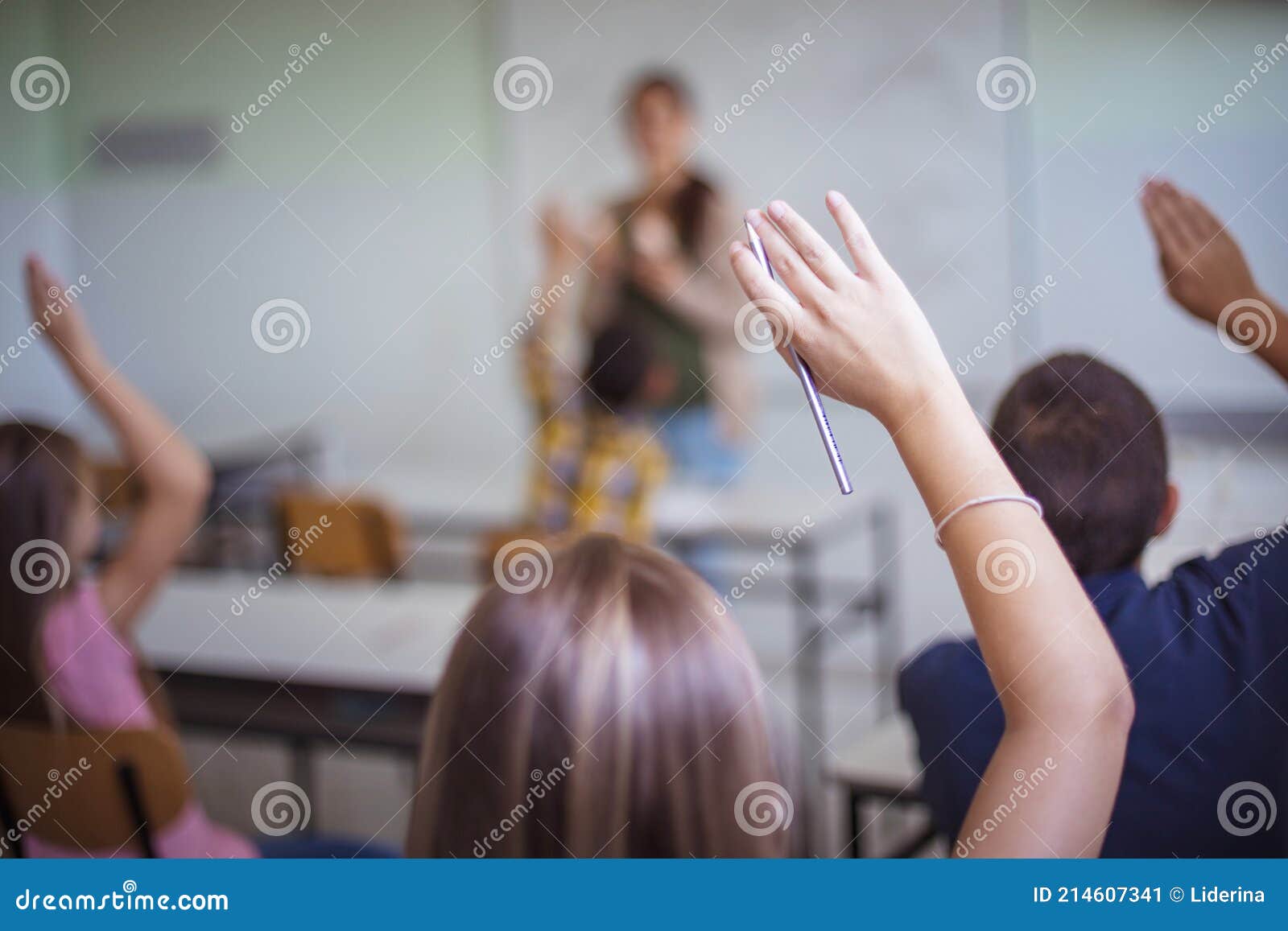 Middle Group of Students Raising Their Arms To Answer the Question ...