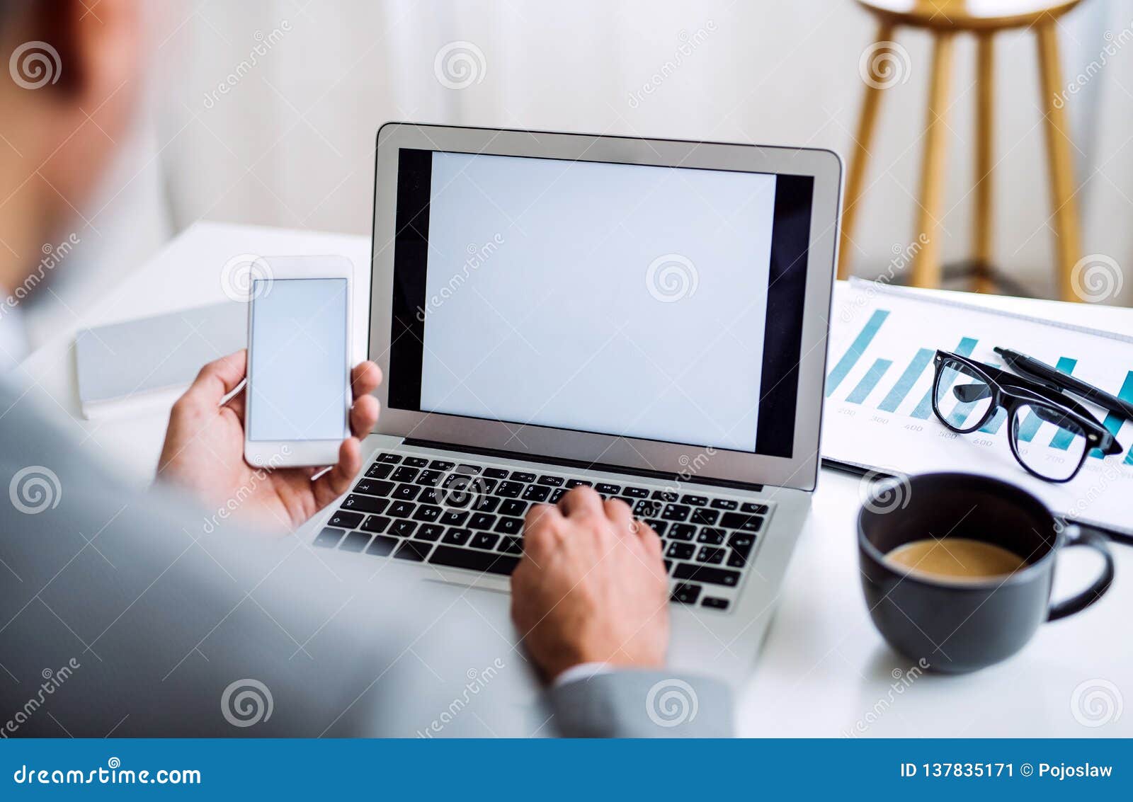 A Midsection of Businessman with Smartphone and Laptop Sitting at the ...