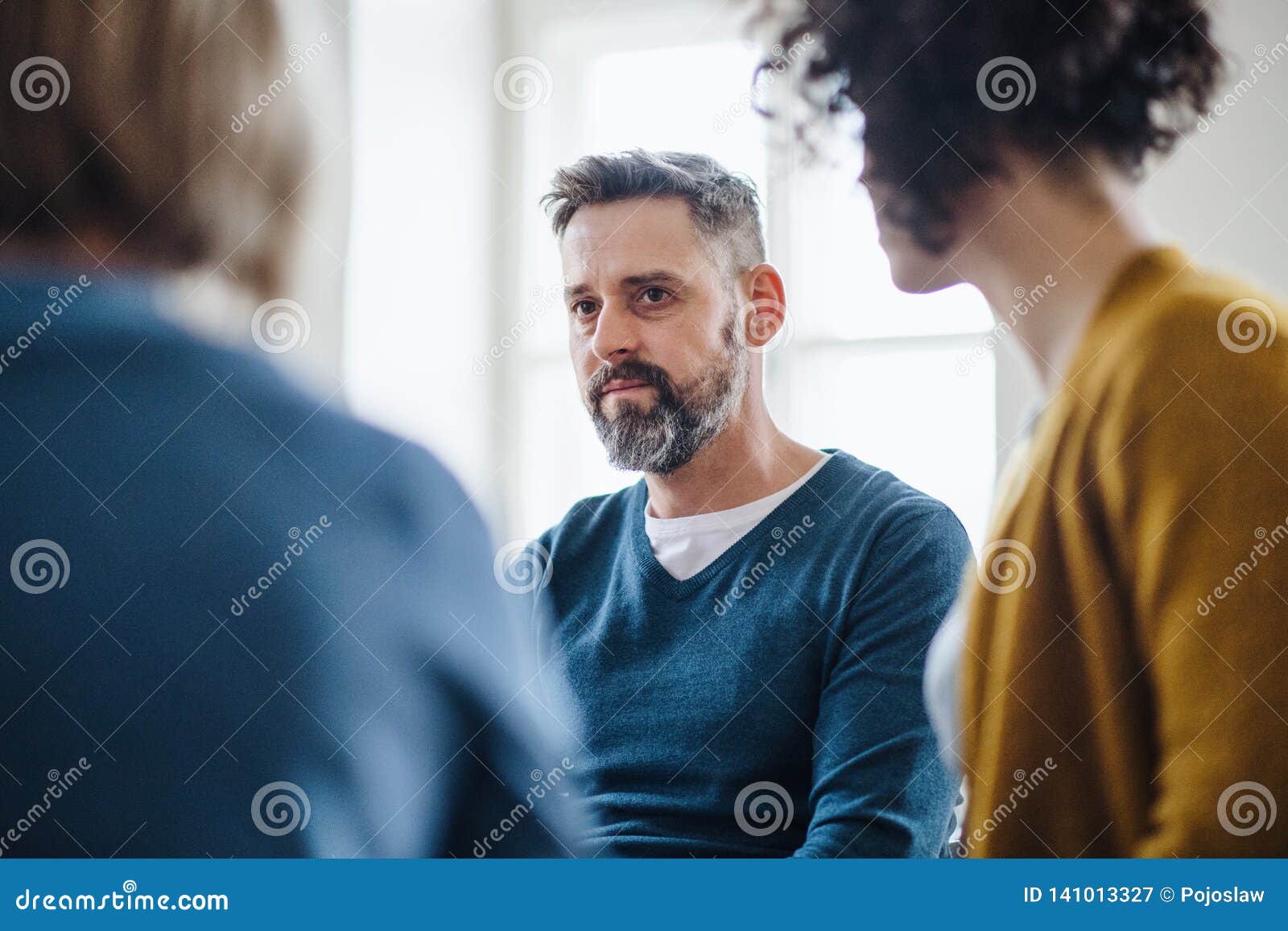 Midsection of Men and Women Sitting in a Circle during Group Therapy ...