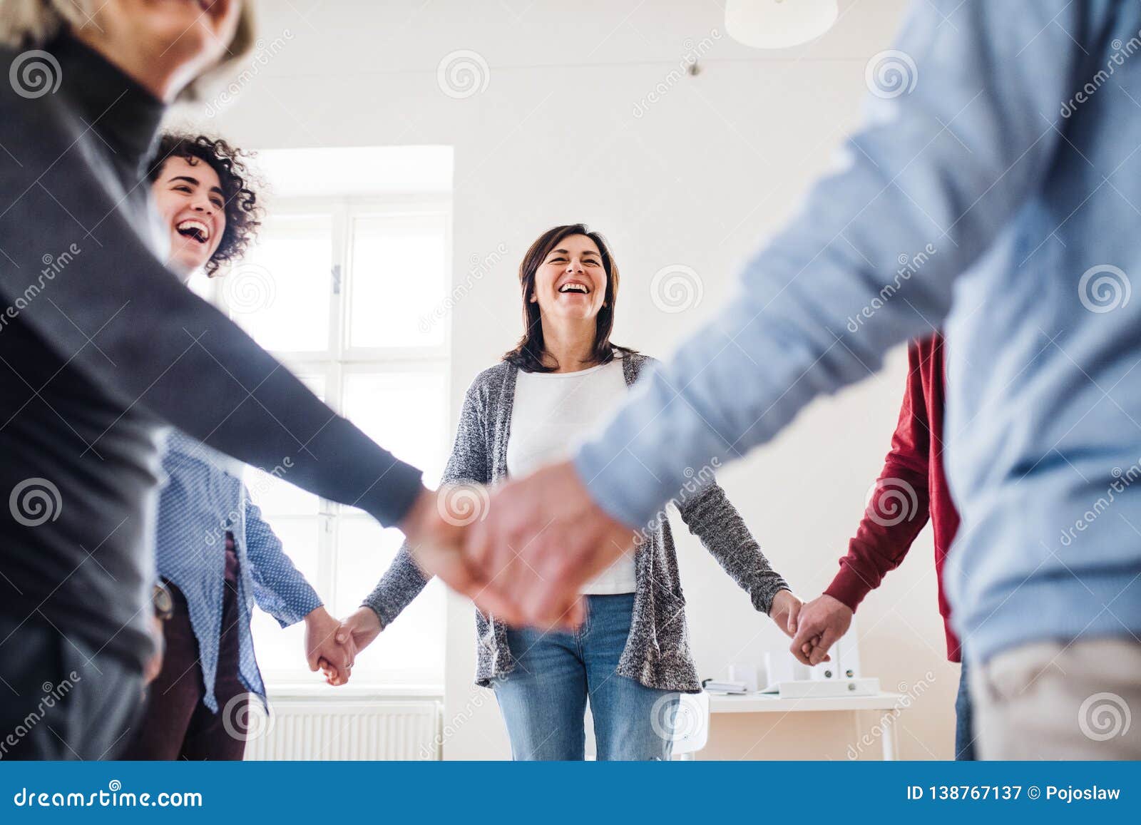 Midsection of People Standing in a Circle and Holding Hands during ...