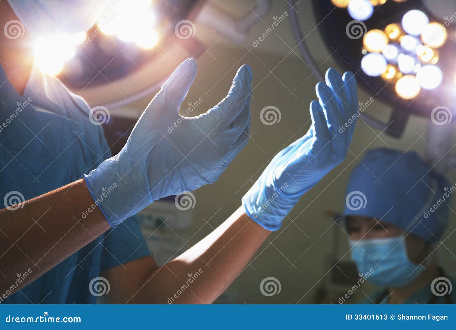 Midsection View of Hands in Surgical Gloves and Surgical Lights in the ...