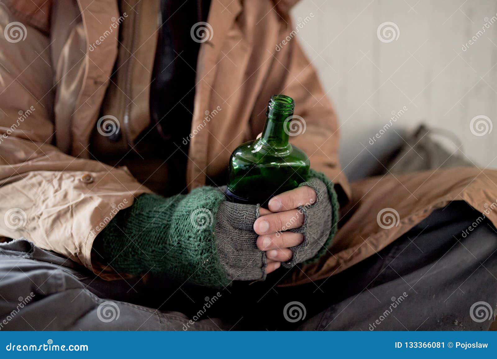A Midsection View Of Homeless Beggar Man Sitting Outdoors Holding