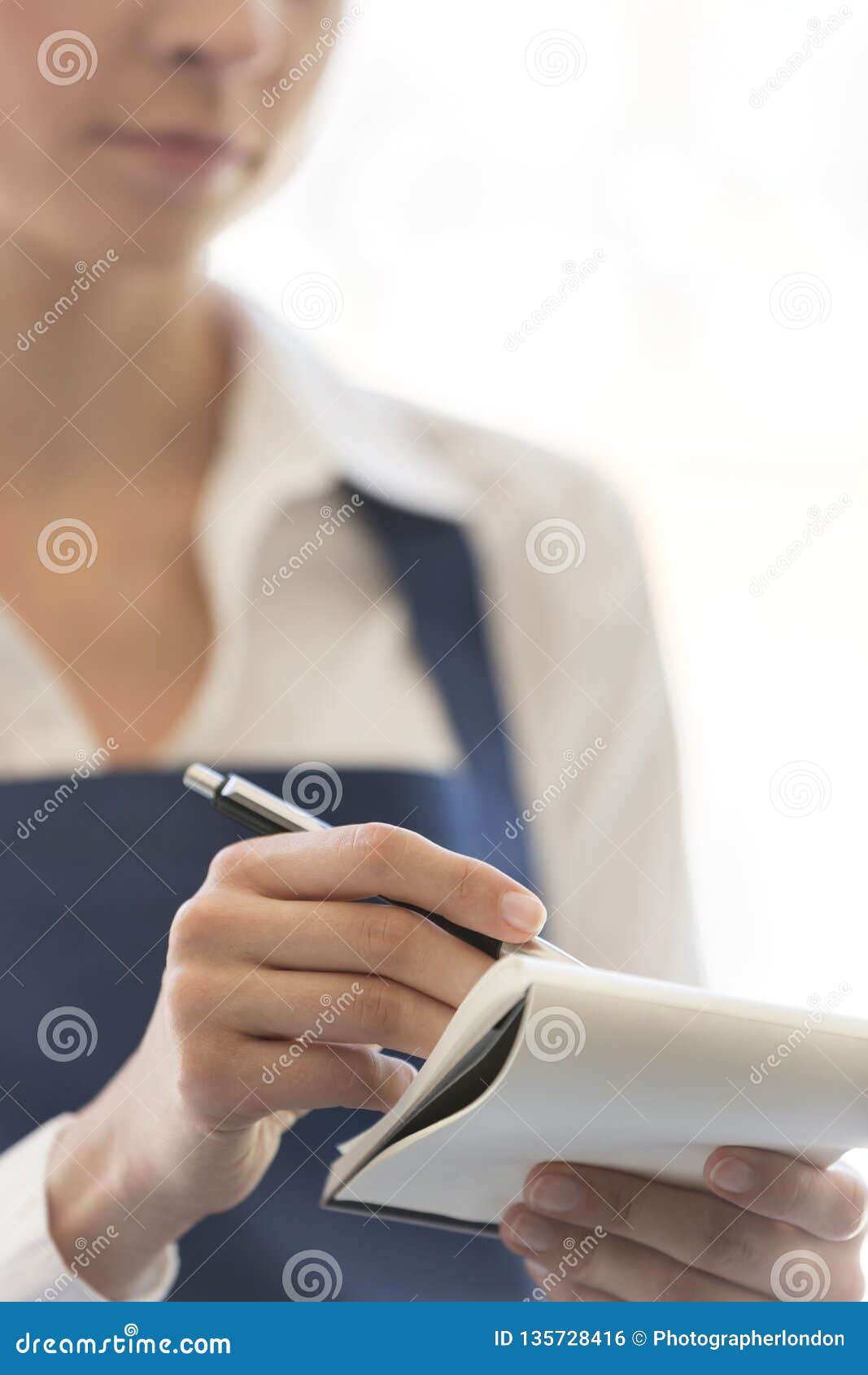 Midsection of Young Waitress Writing on Notepad at Restaurant Stock ...