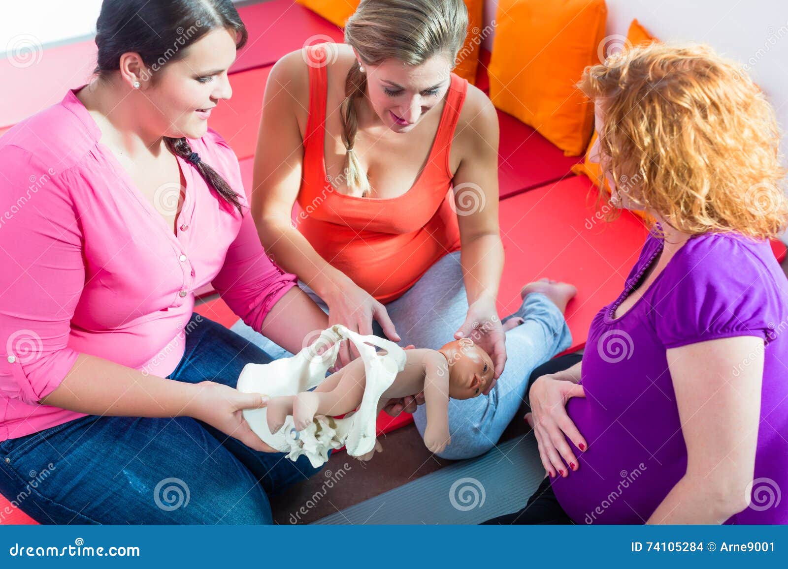 Midwife Explaining Birth Process To Pregnant Women During Antenatal