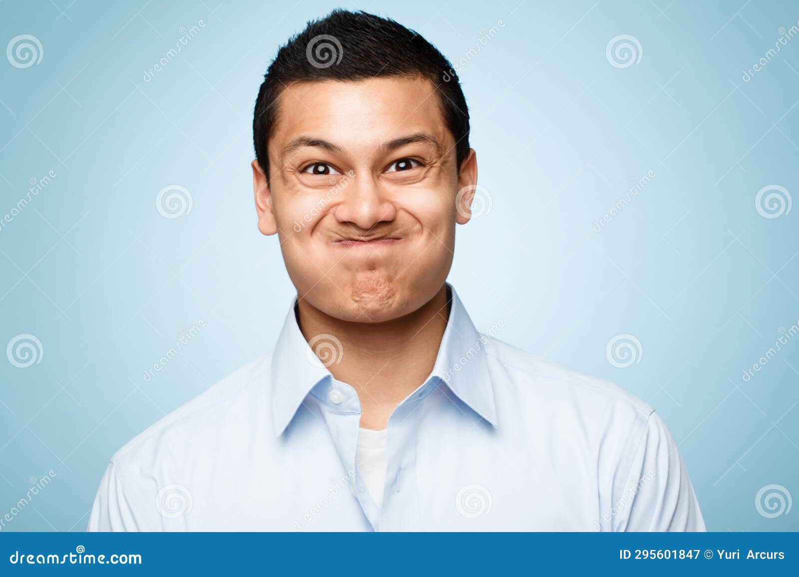 He Might Just Explode. a Young Man Making Facial Expressions Against a ...