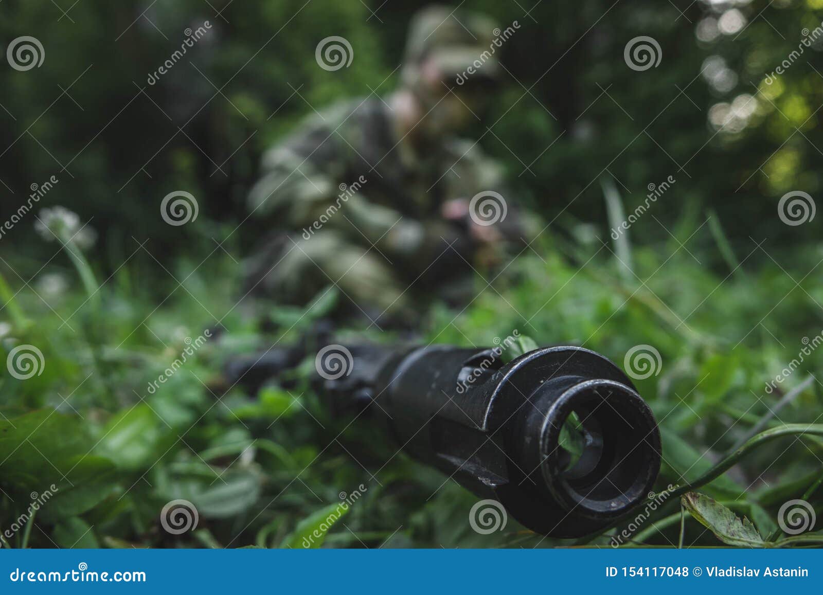 The Military Sits on the Grass and Examines His Gun. Stock Photo ...