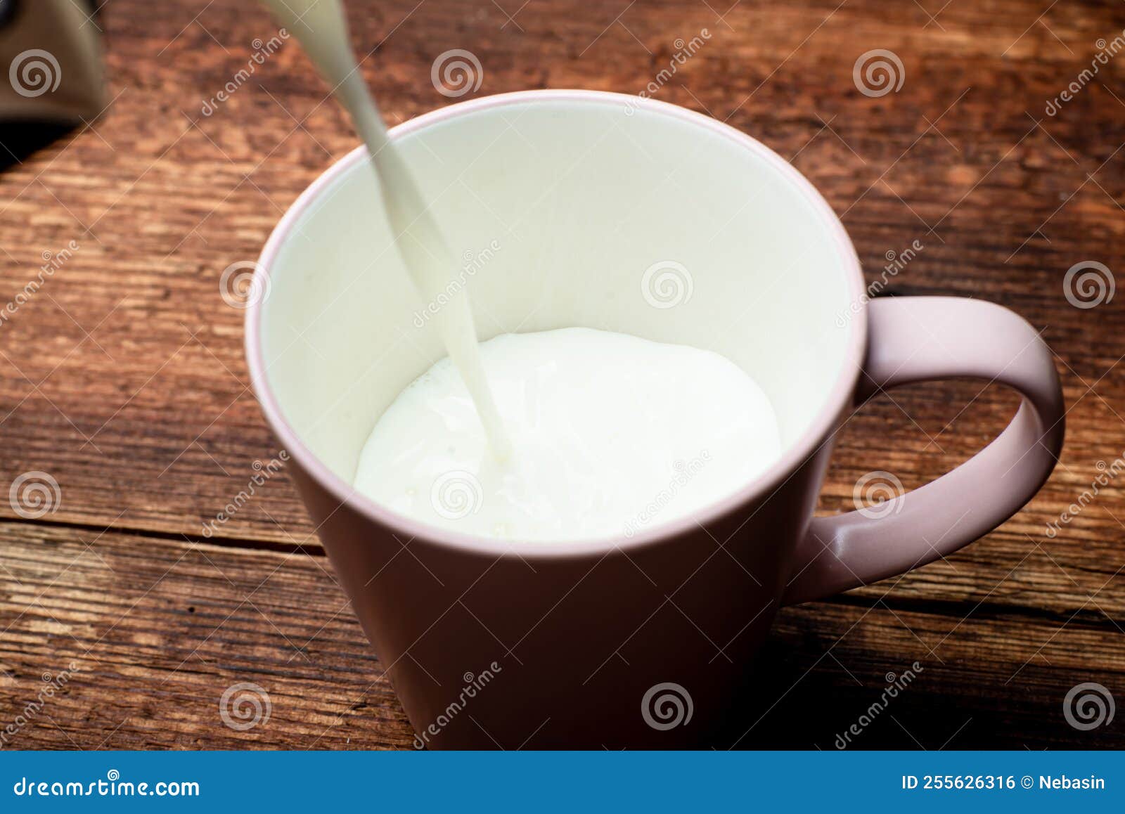 Milk is Poured into a Cup on a Brown Wooden Background Stock Photo ...