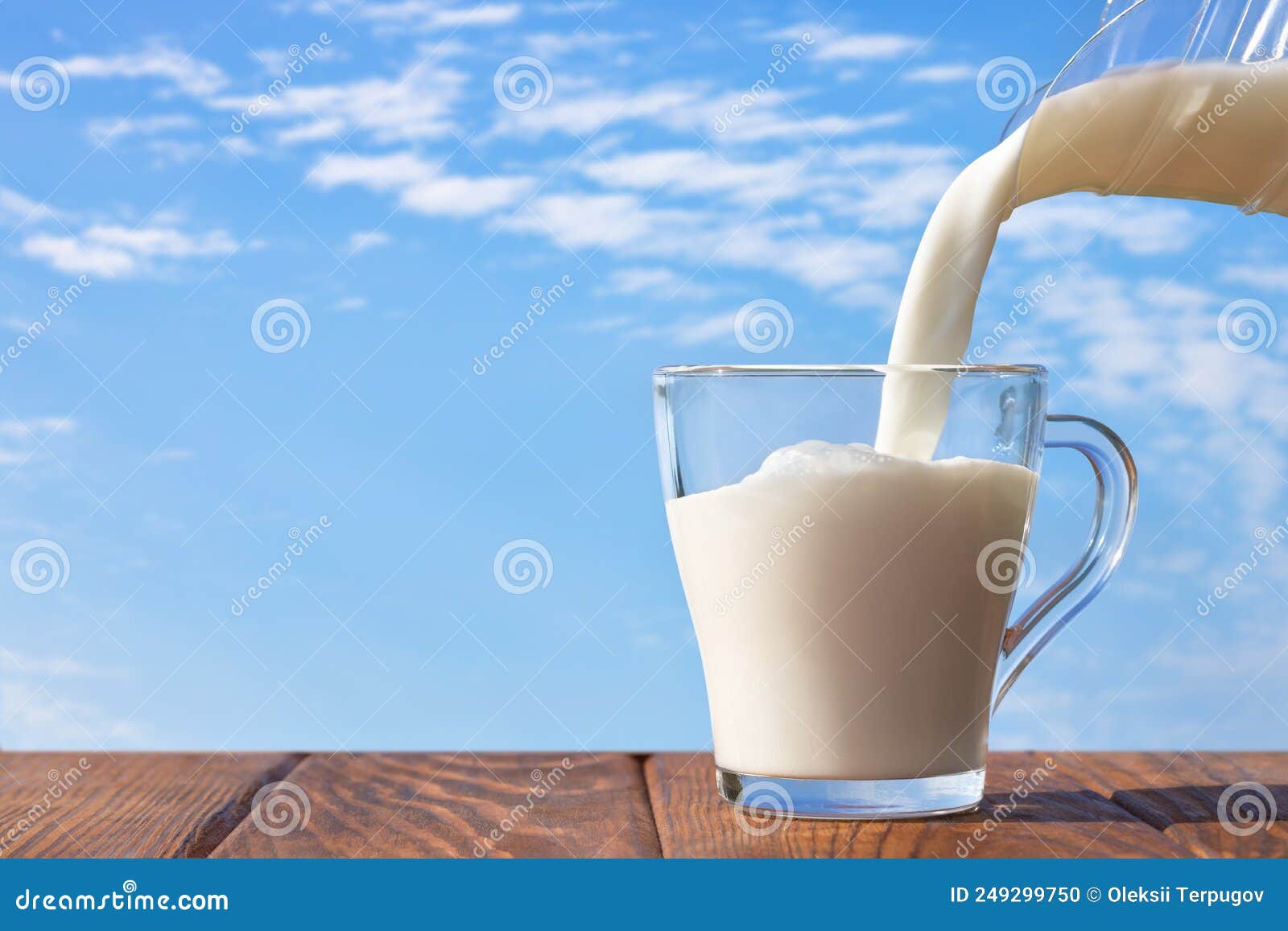 Milk Pouring from Jug into Glass Cup on Table Stock Photo - Image of ...