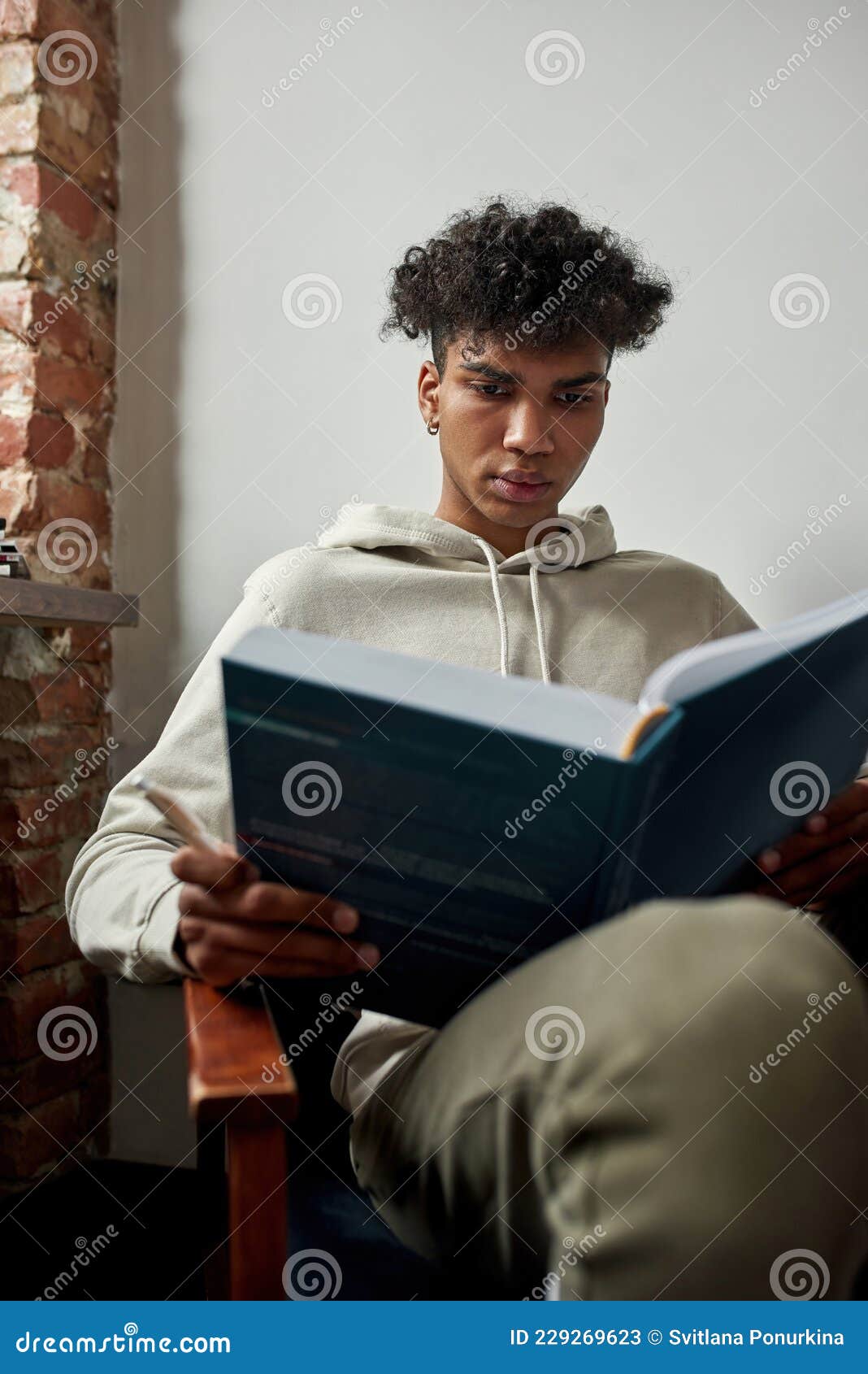 Millennial African American Guy Read Book In Chair Stock Image Image