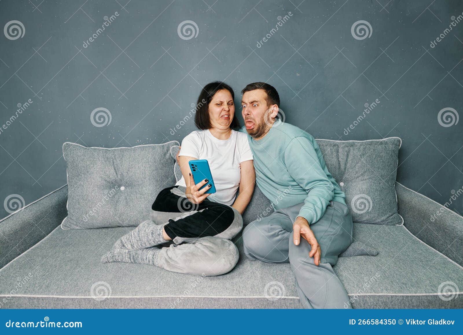 Millennial Couple with Disgust Expression Looking at Smartphone Stock ...