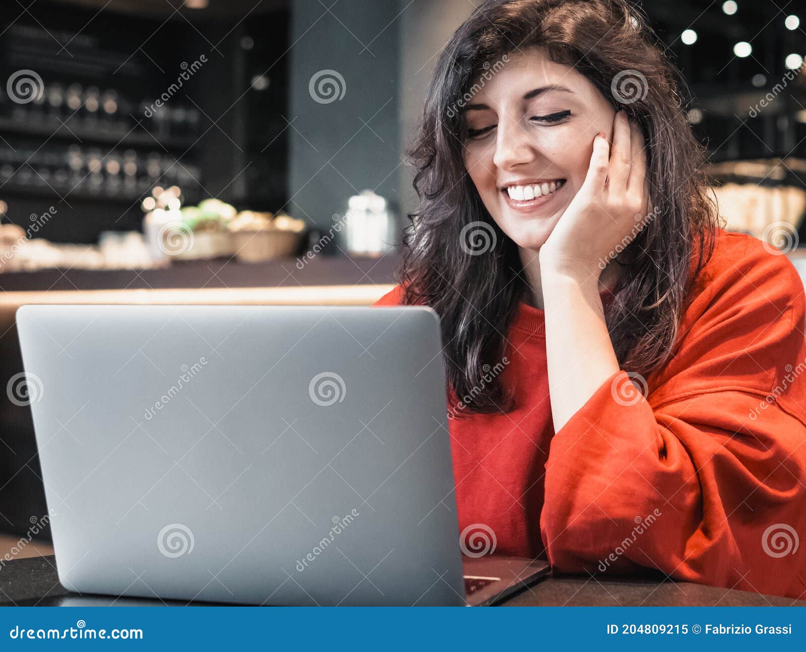 Millennial Girl Smiles while Working on the Pc in a Cafe - Remote ...